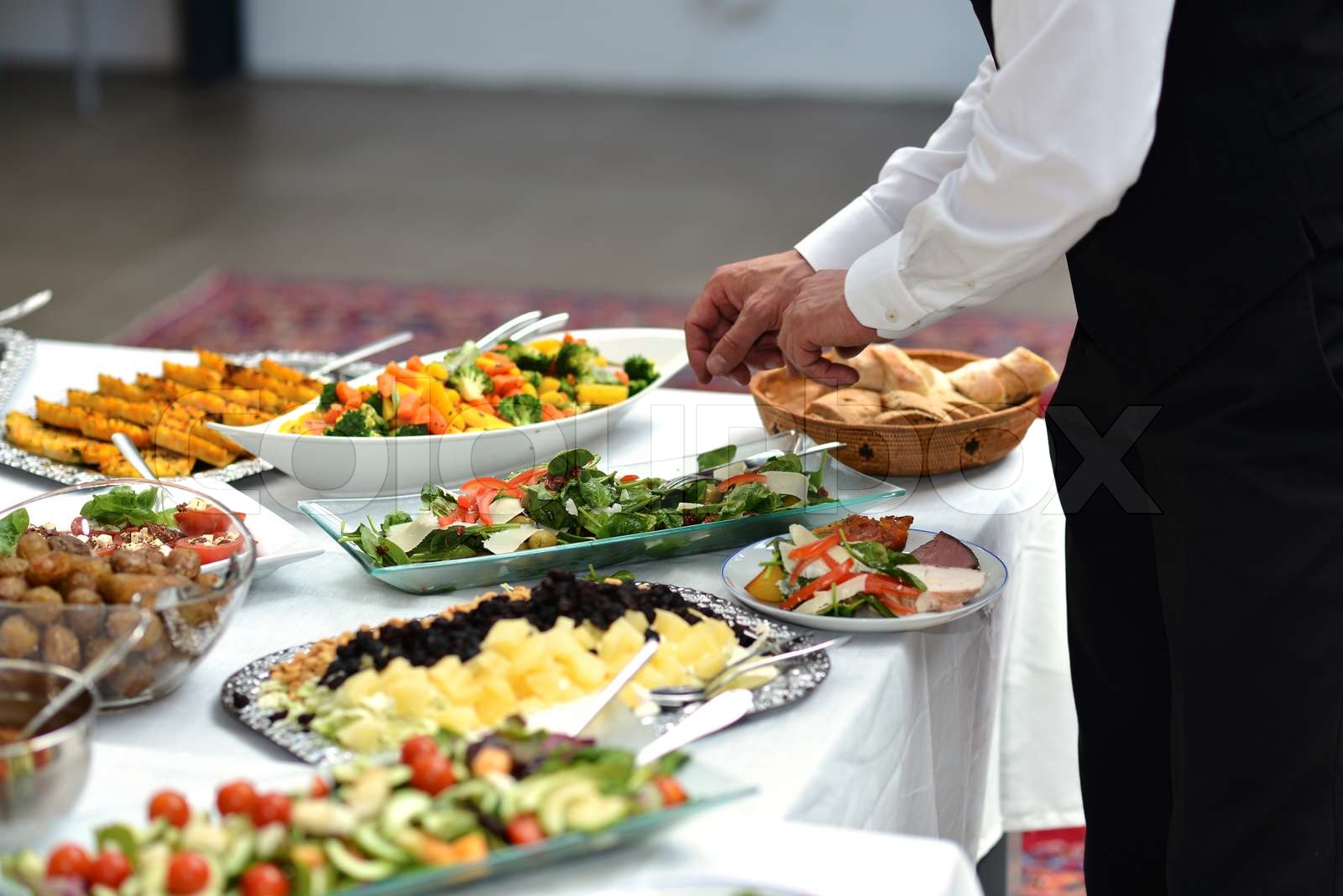 Close up on man picking up food from buffet | Stock image | Colourbox