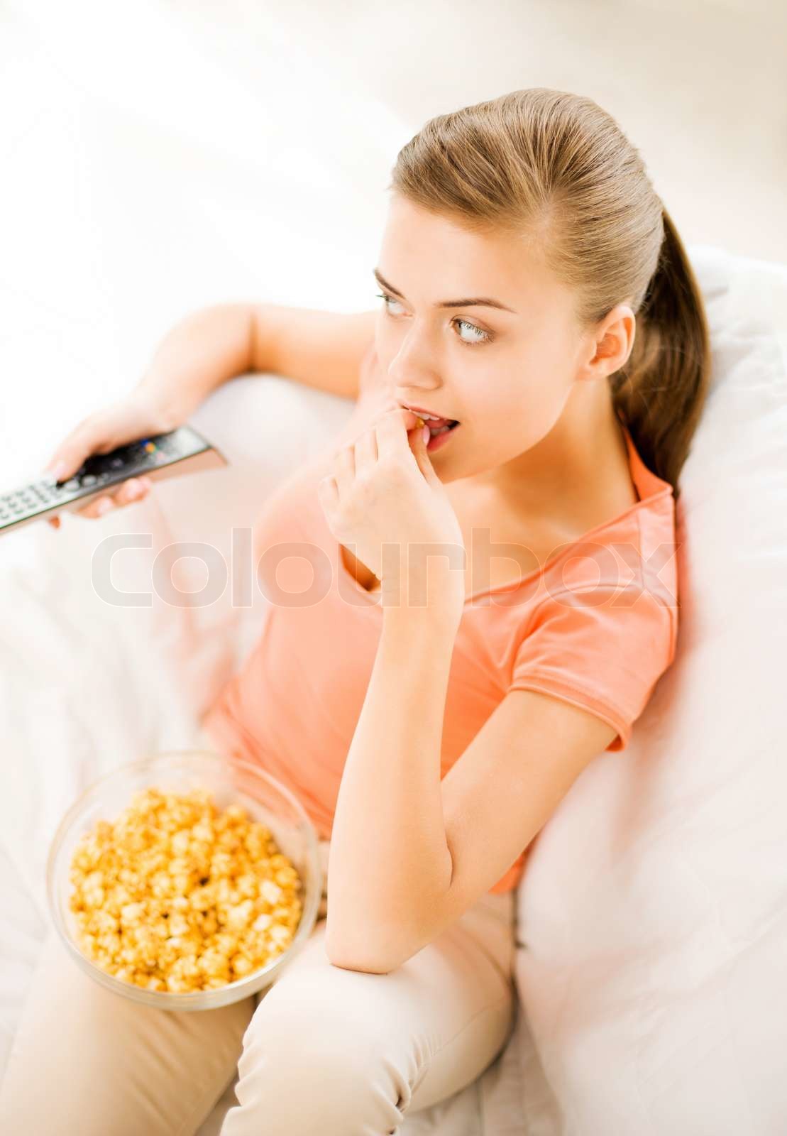woman watching tv and eating popcorn | Stock image | Colourbox