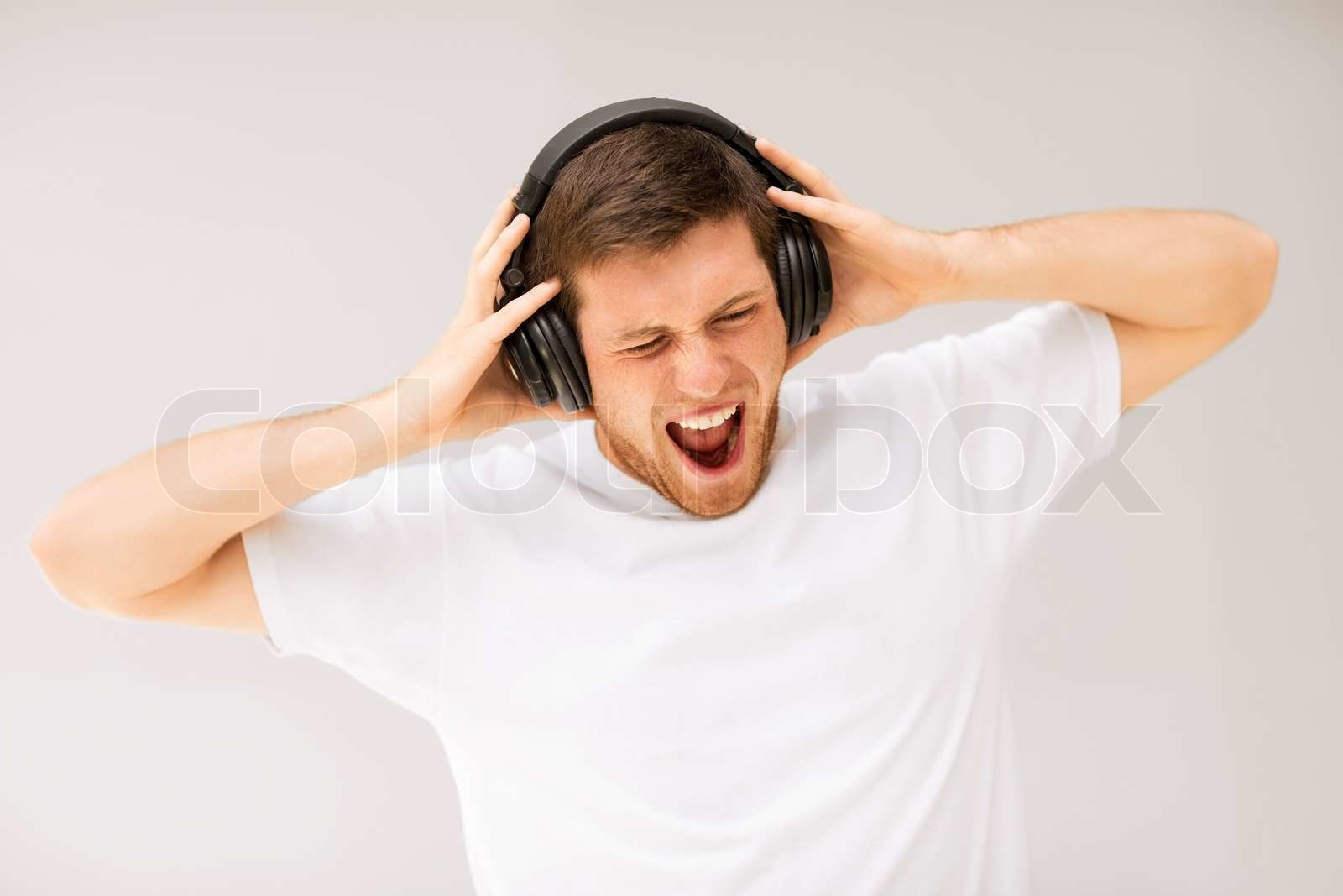 Mann mit Kopfhörern hören laute Musik | Stock Bild | Colourbox