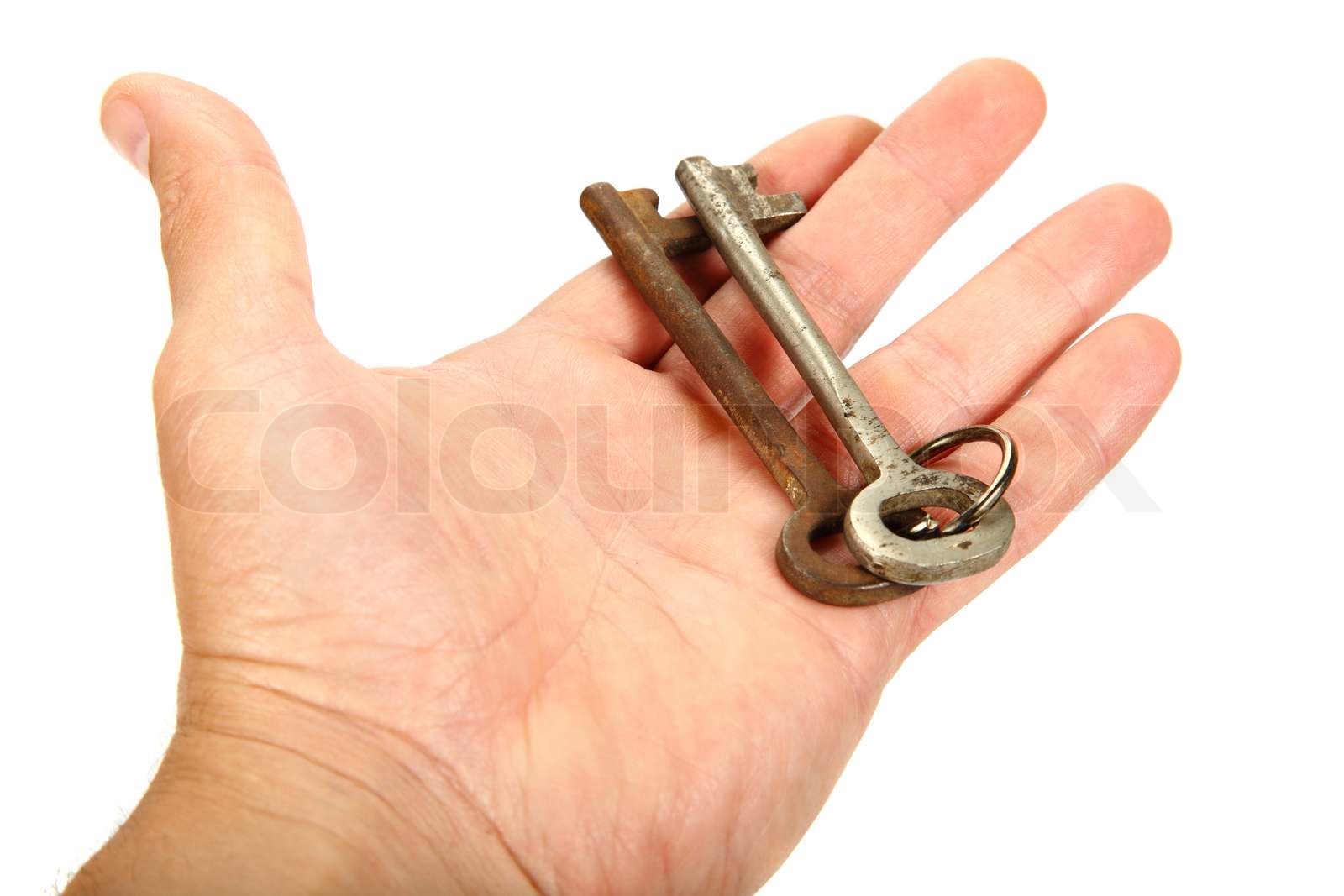 Zwei alte Schlüssel in der Hand auf einem weißen Hintergrund isoliert ...
