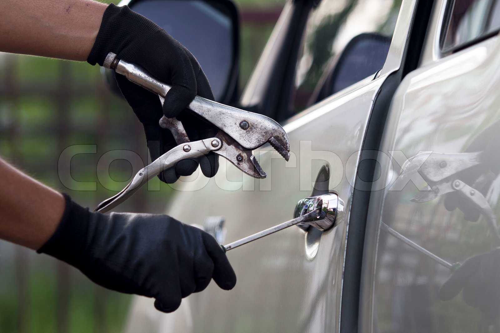Car thief ,Shot of a male using a tool to break into a car | Stock ...