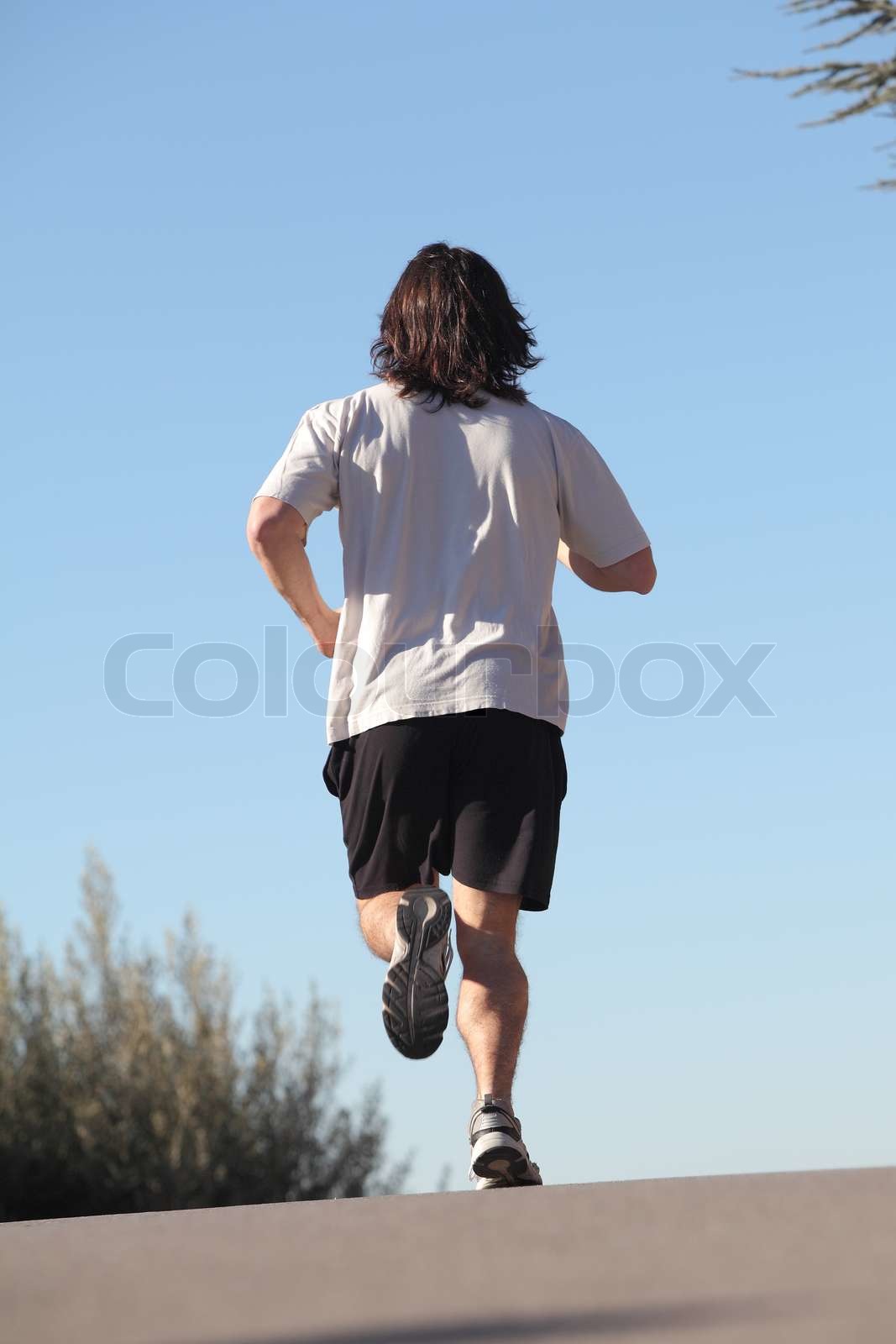 Back view of a man running on a road | Stock image | Colourbox