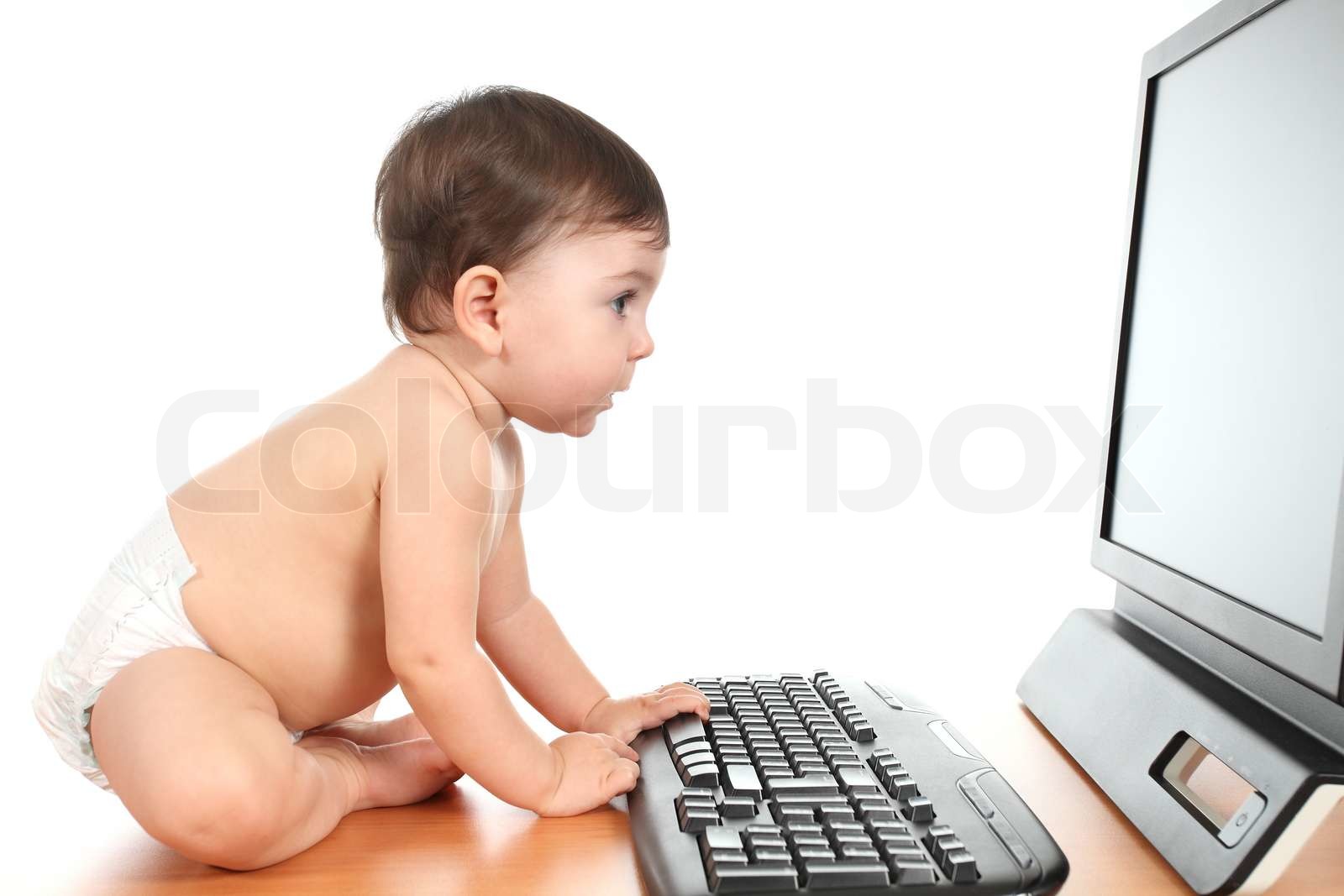 Baby typing on a computer keyboard | Stock image | Colourbox