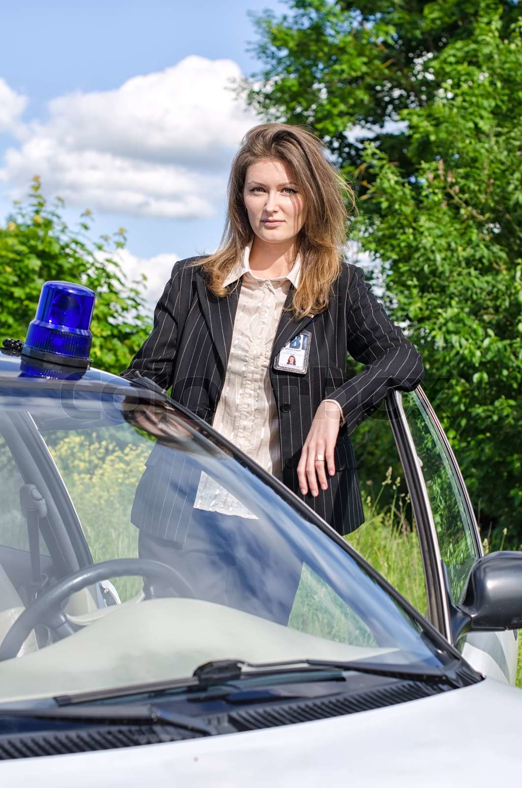 Young female FBI agent standing near car open door | Stock image ...