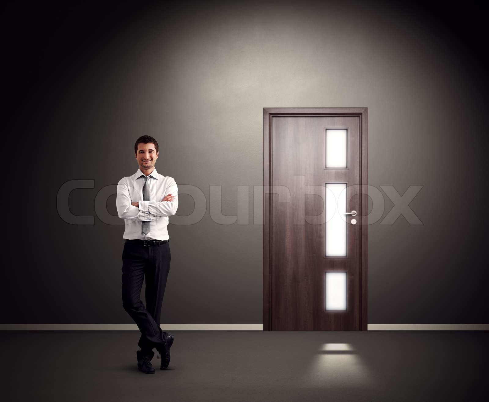 man standing against wall with door | Stock image | Colourbox