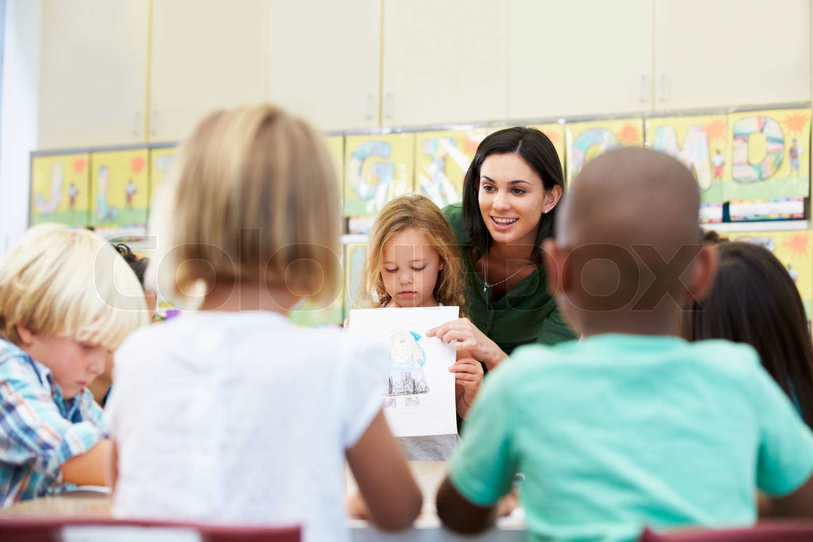 Elementary Pupil Showing Drawing To Classmates In Classroom | Stock ...