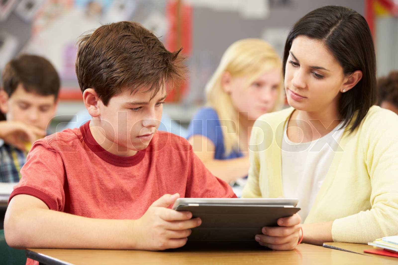 Pupils In Class Using Digital Tablet With Teacher | Stock image | Colourbox