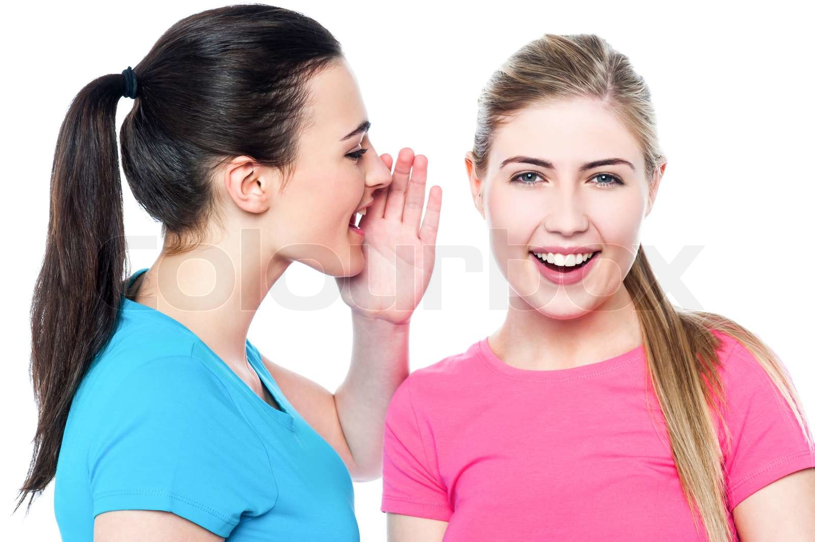 Two pretty young girls gossiping | Stock image | Colourbox