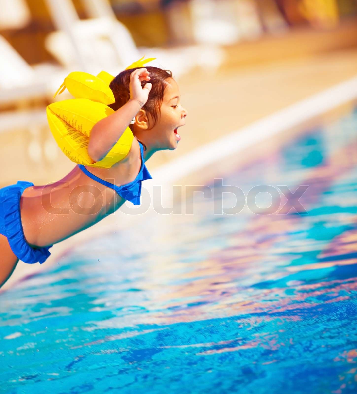 Little girl jumping into the pool | Stock image | Colourbox