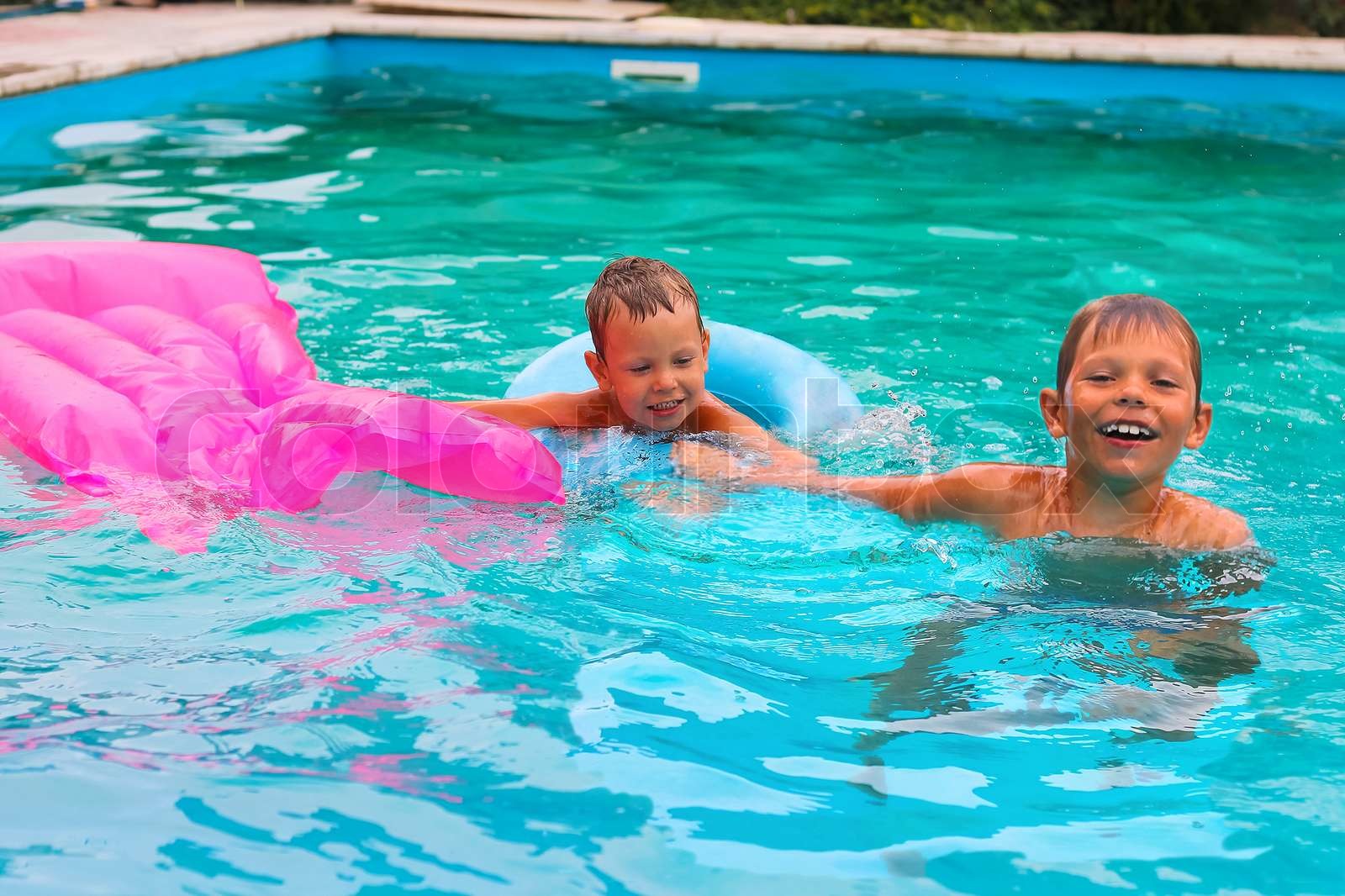Two brothers are swimming in the pool | Stock image | Colourbox