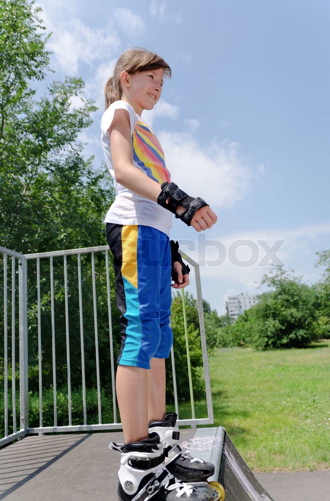 Young girl poised at the top of a skating ramp | Stock image | Colourbox