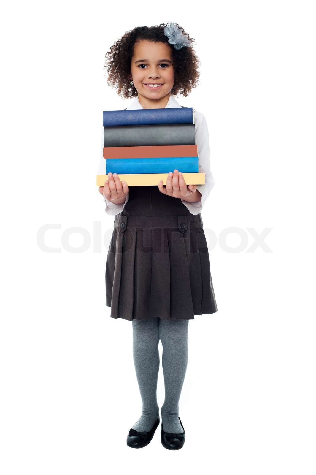 Active school child carrying stack of books | Stock image | Colourbox