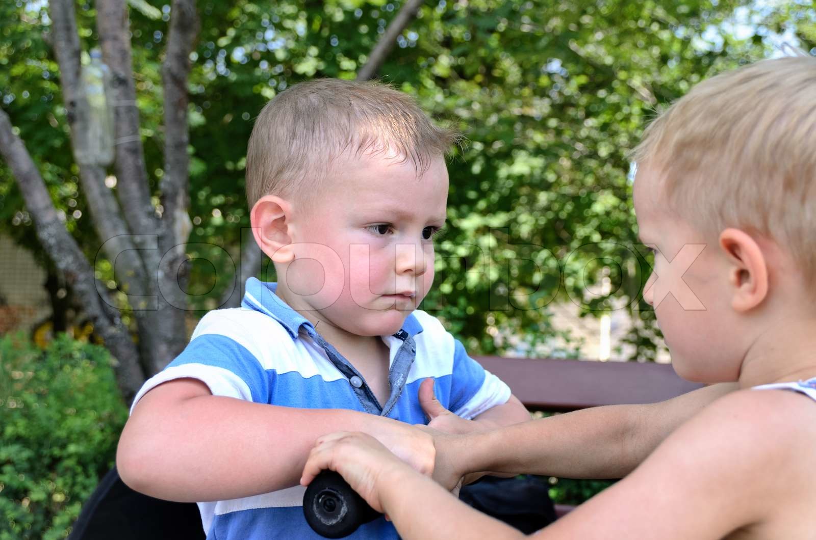 Two young boys arguing over a scooter | Stock image | Colourbox