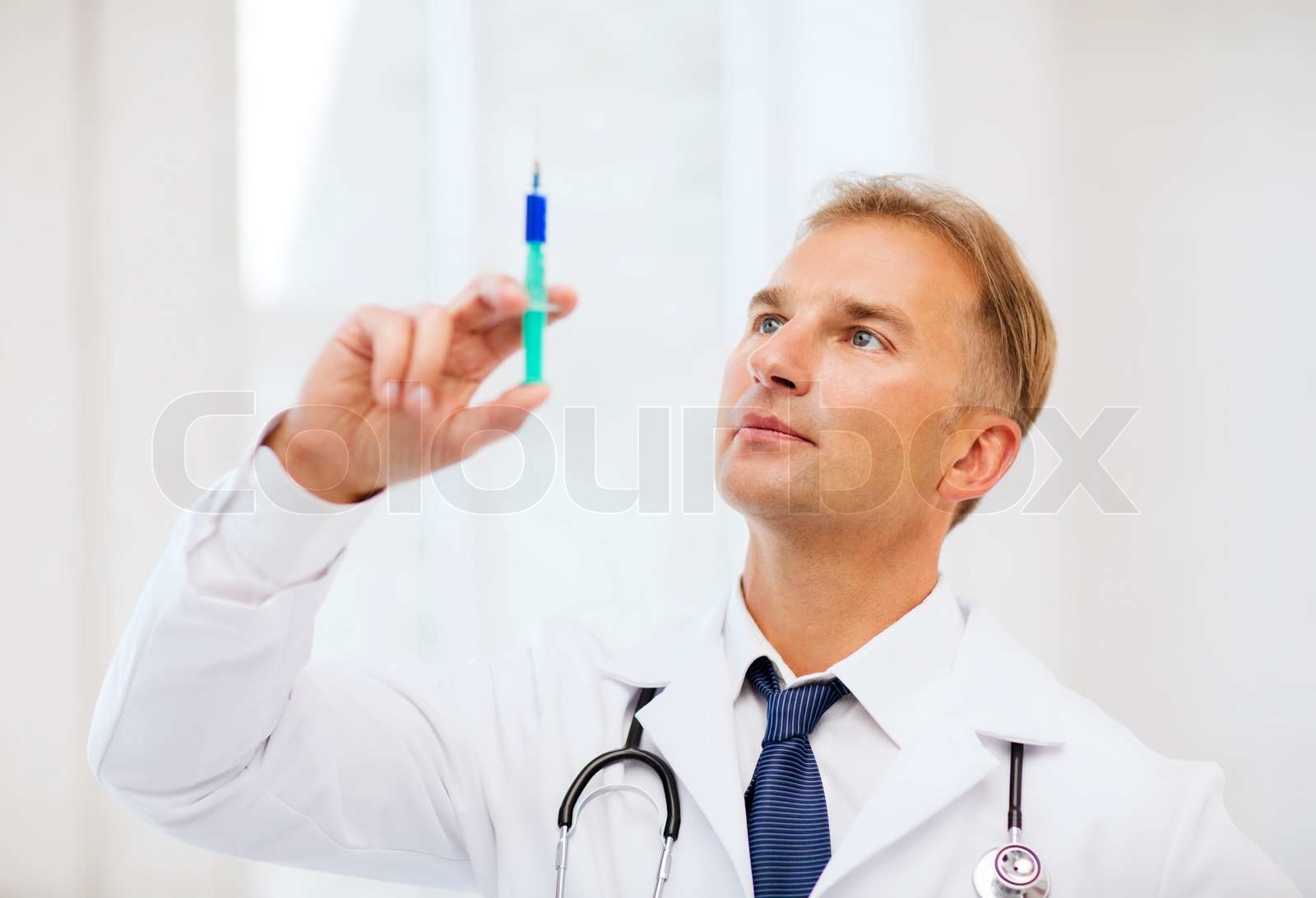 mandlig læge bedrift sprøjte med injektion | Stock foto | Colourbox