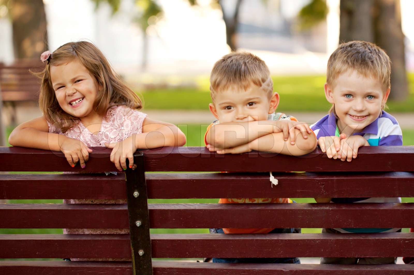 Drei glückliche childrenpeeking über den Zaun | Stock Bild | Colourbox