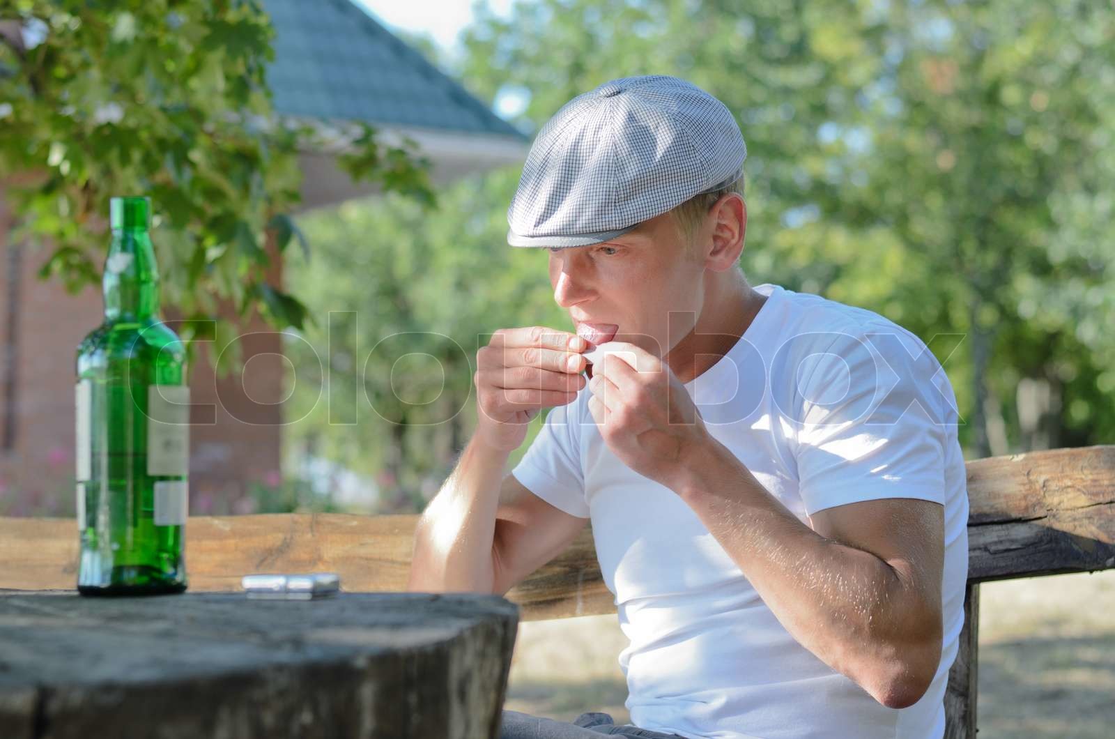 Man rolling a cigarette sealing the paper | Stock image | Colourbox