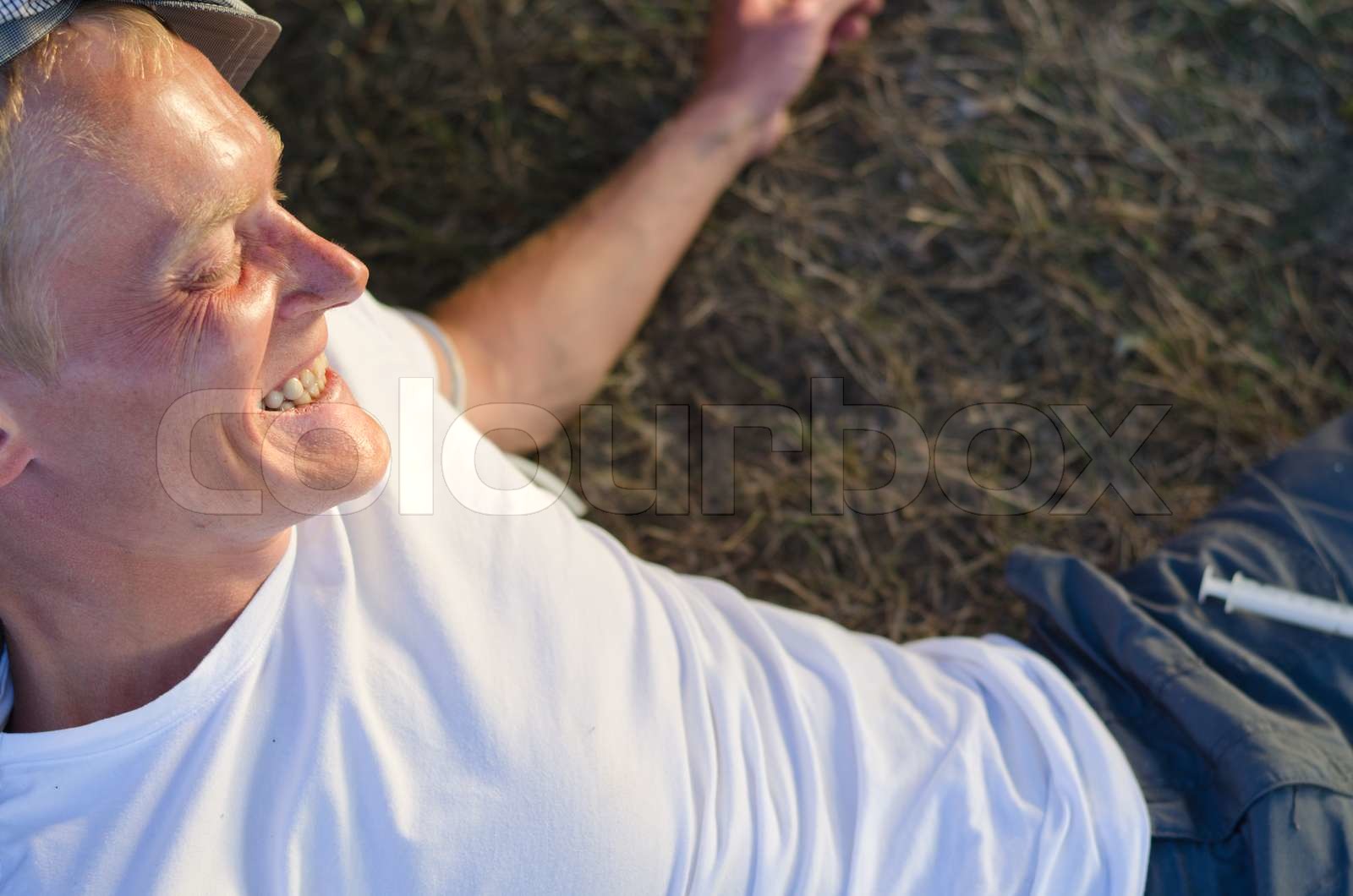 Addicted Mann lachend liegend auf Gras | Stock Bild | Colourbox