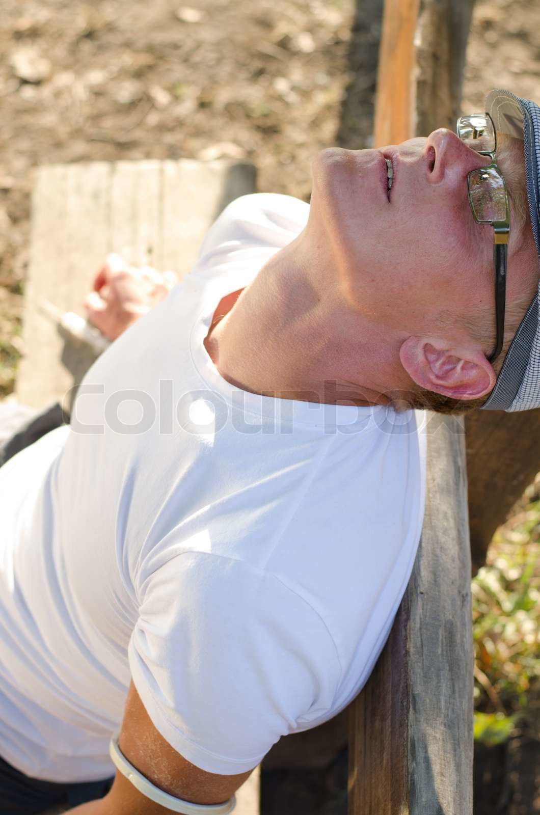 Drug addict passed out on a bench | Stock image | Colourbox