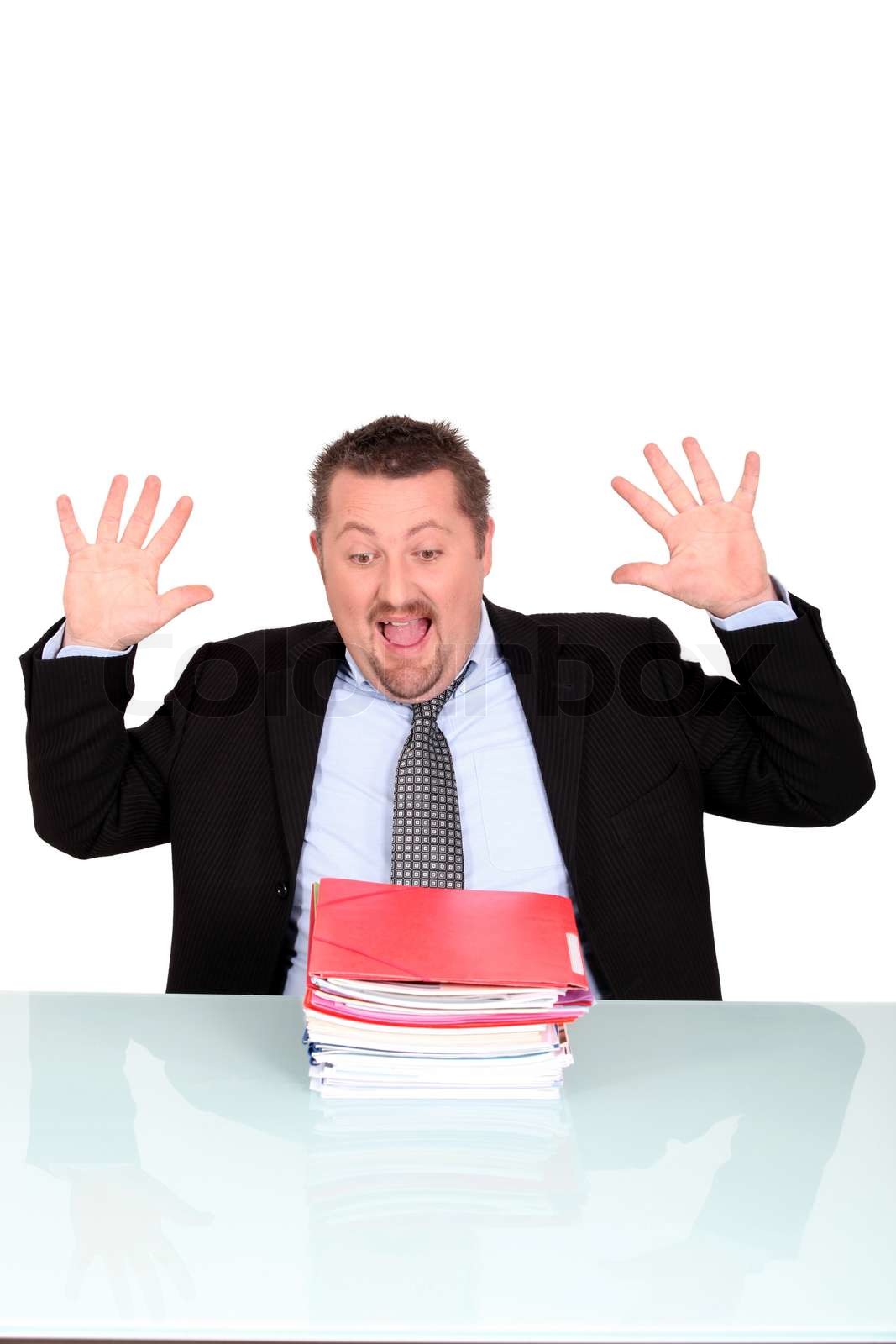 Man shocked at his pile of paperwork | Stock image | Colourbox