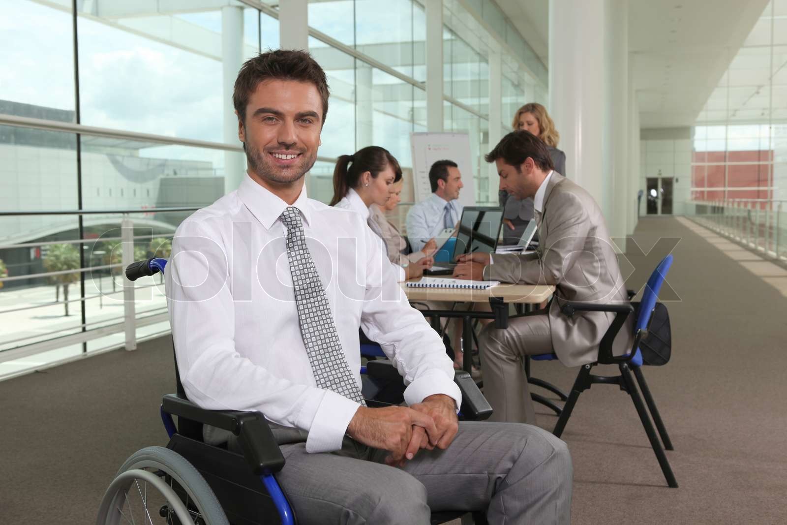 Disabled office worker with colleagues | Stock image | Colourbox