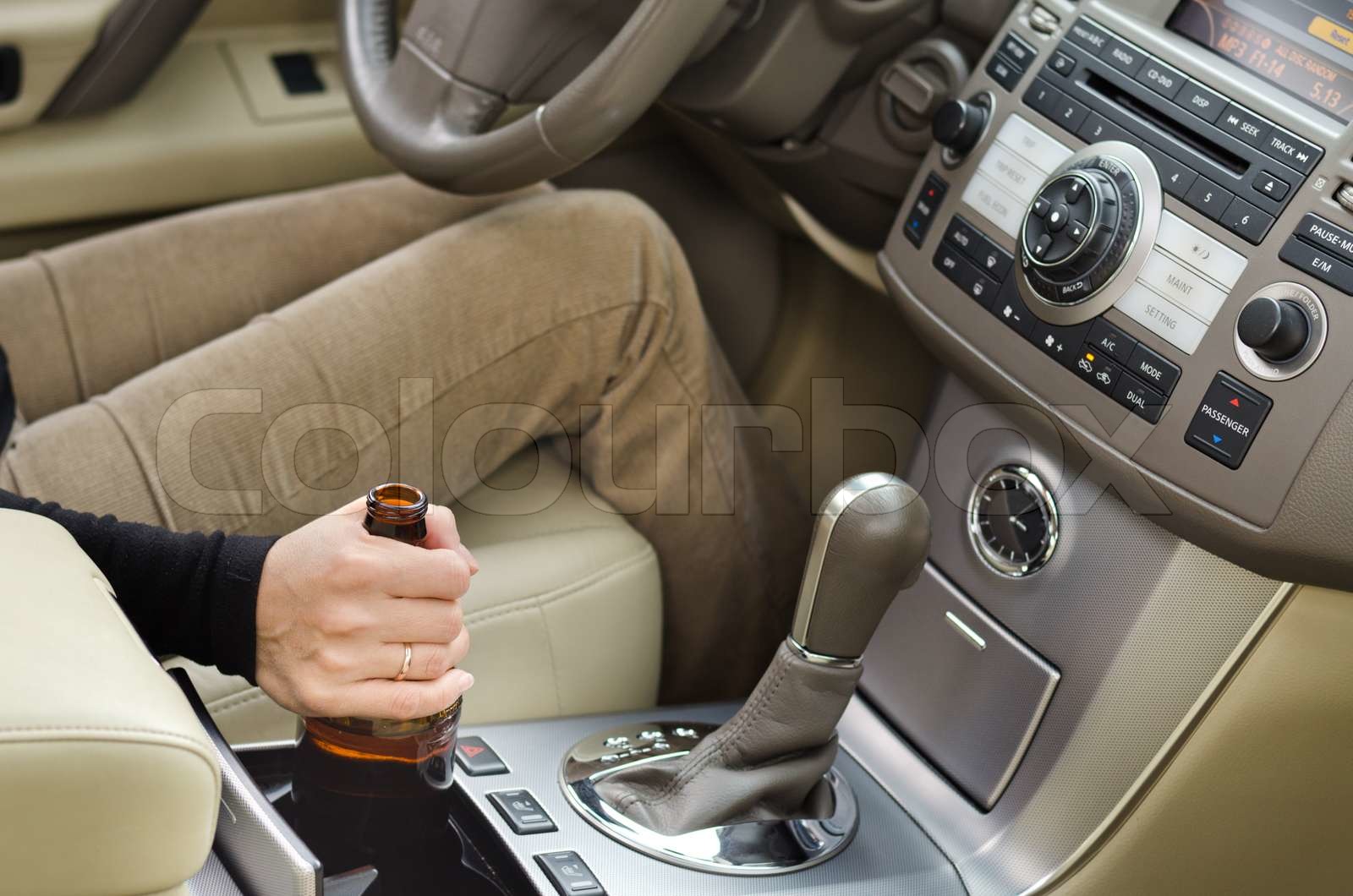 Woman alcoholic with a bottle of booze in the car | Stock image | Colourbox
