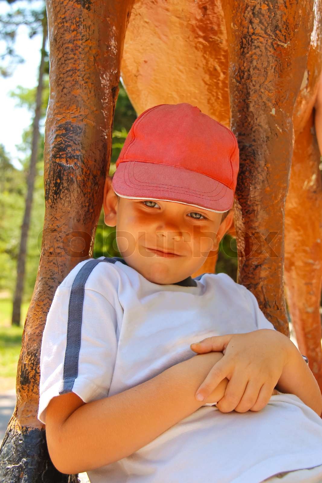 Smiling kid wearing a cap in the summer park | Stock image | Colourbox