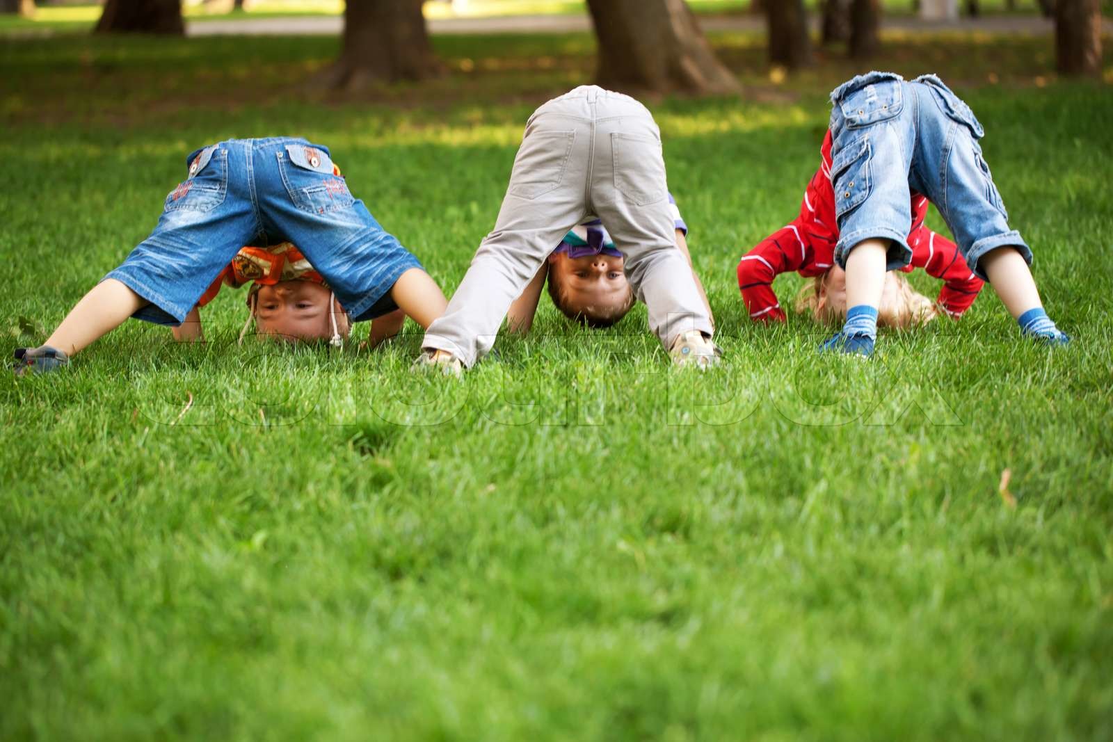 Three little boys turning somersaults | Stock image | Colourbox
