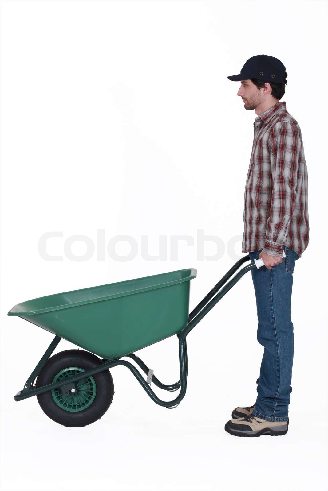 Profile shot of man stood with wheelbarrow | Stock image | Colourbox