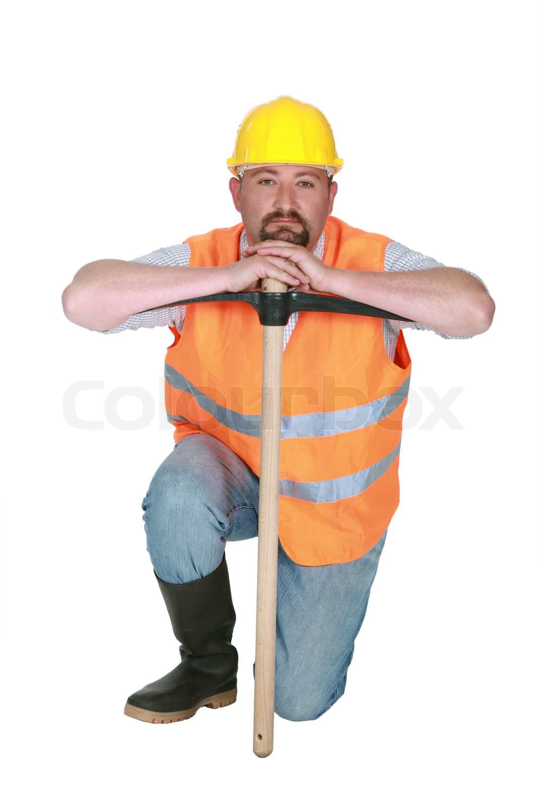 Construction worker leaning on a pickaxe | Stock image | Colourbox
