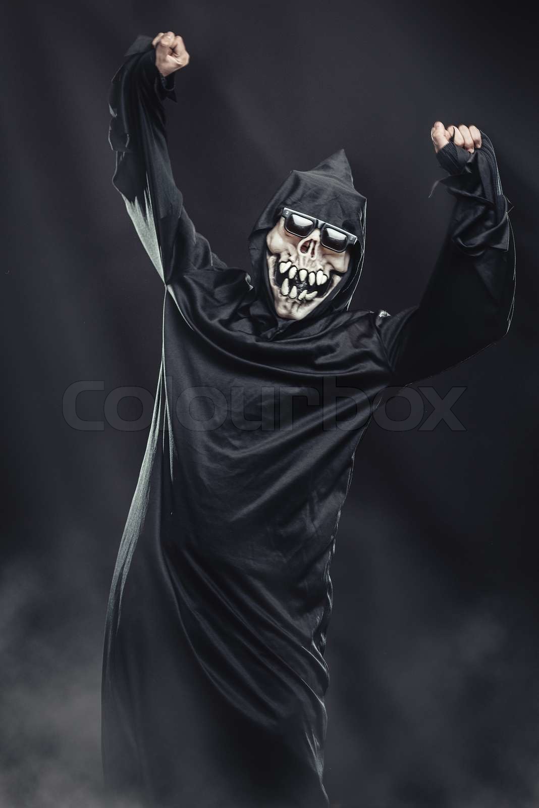 skeleton in a black robe with glasses dancing | Stock image | Colourbox
