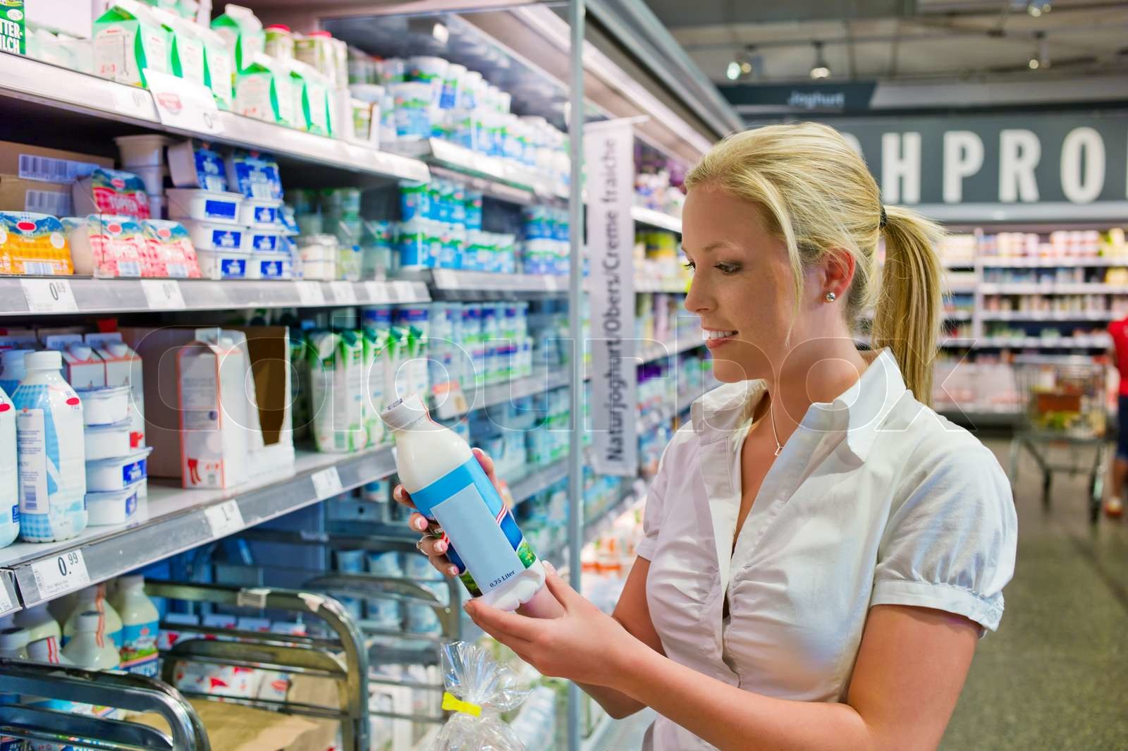 woman buying milk at the grocery store | Stock image | Colourbox