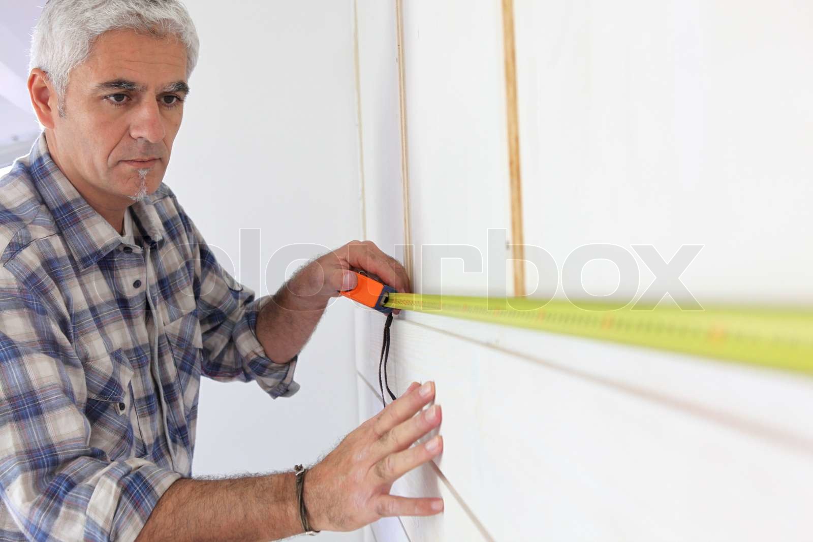 Man measuring wall | Stock image | Colourbox