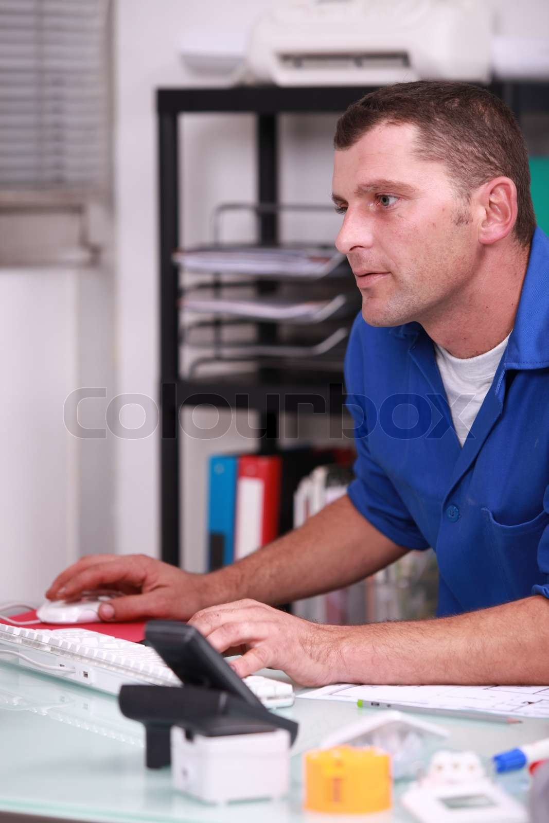 Plumber using a desktop computer | Stock image | Colourbox