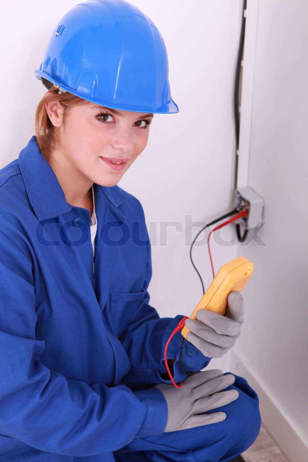 dow-eyed female electrician at work with tester | Stock image | Colourbox