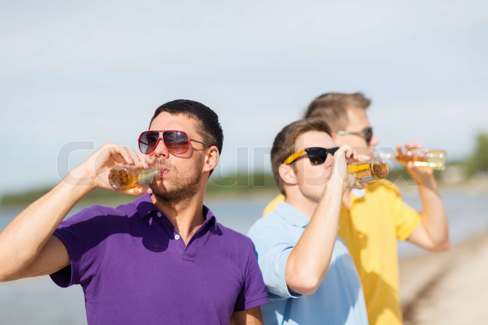 venner på stranden med flasker drink | Stock foto | Colourbox