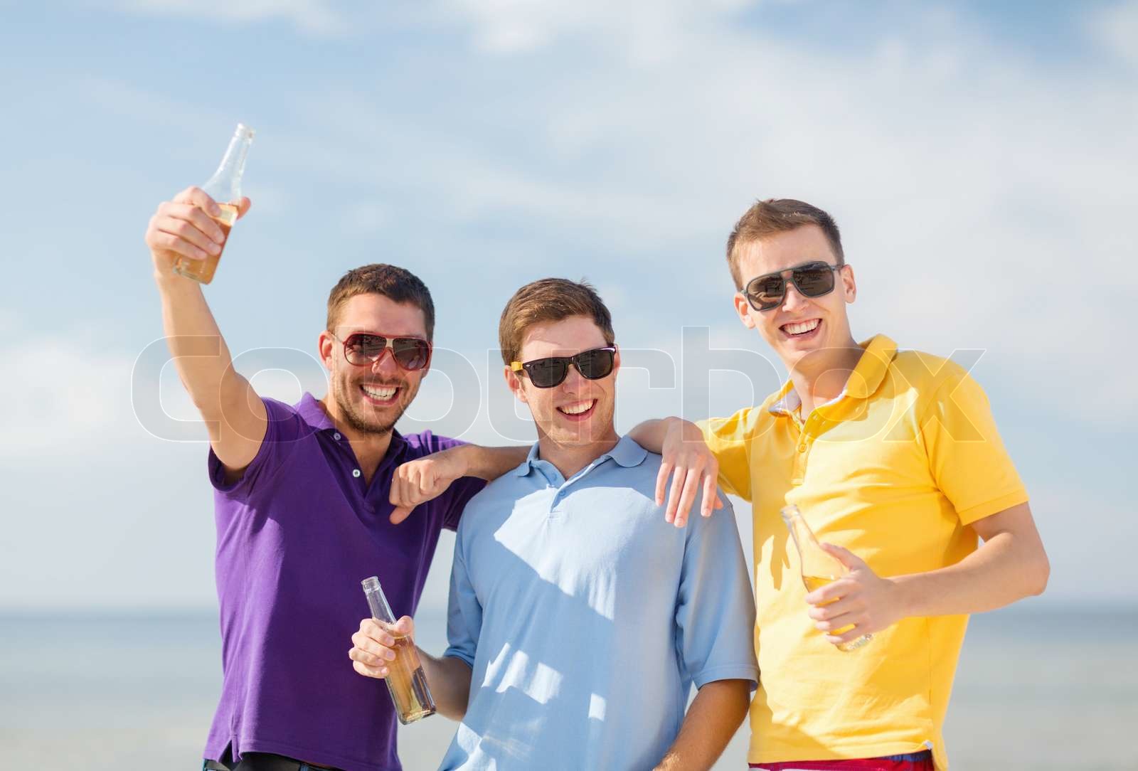 Freunde am Strand mit Flaschen trinken | Stock Bild | Colourbox