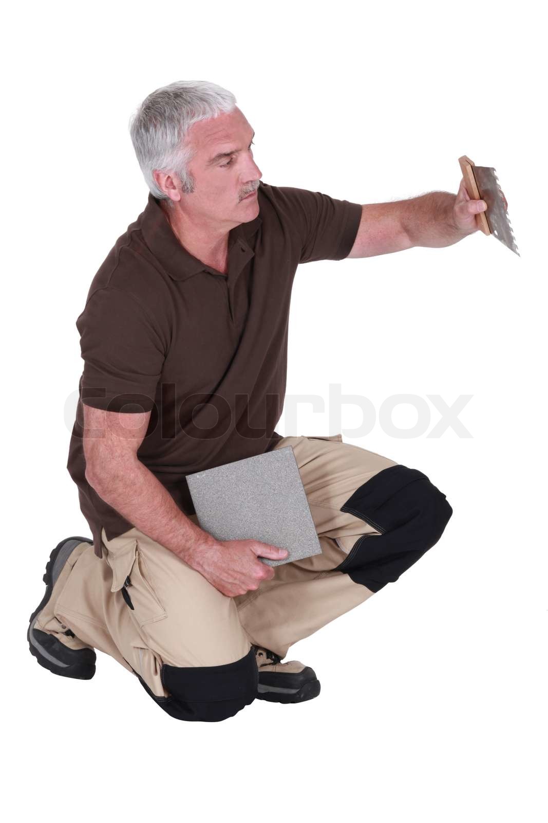 Man tiling wall | Stock image | Colourbox