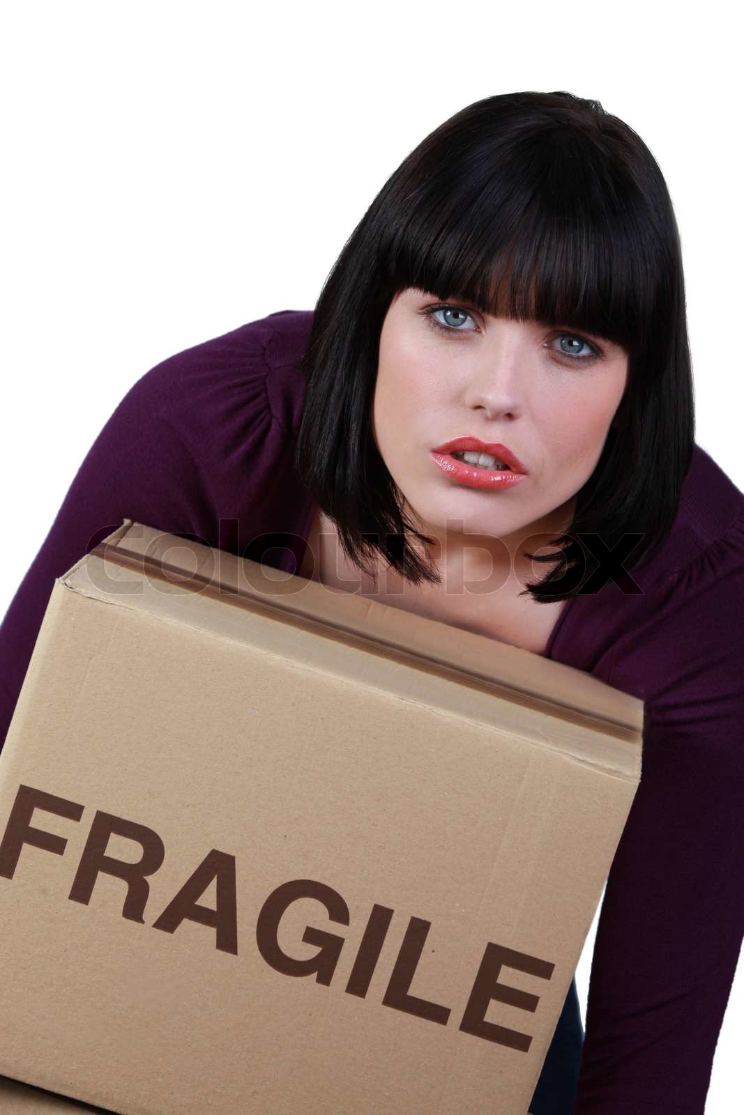 Woman carrying a heavy box marked fragile | Stock image | Colourbox