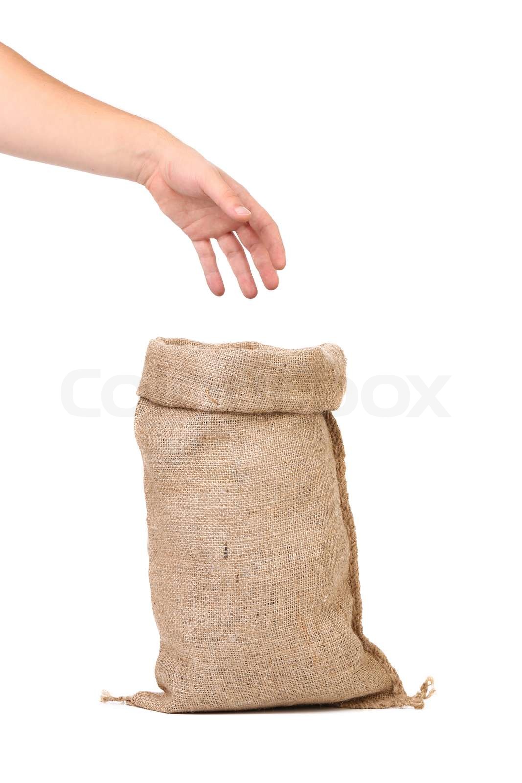Hand picking up from full sack | Stock image | Colourbox
