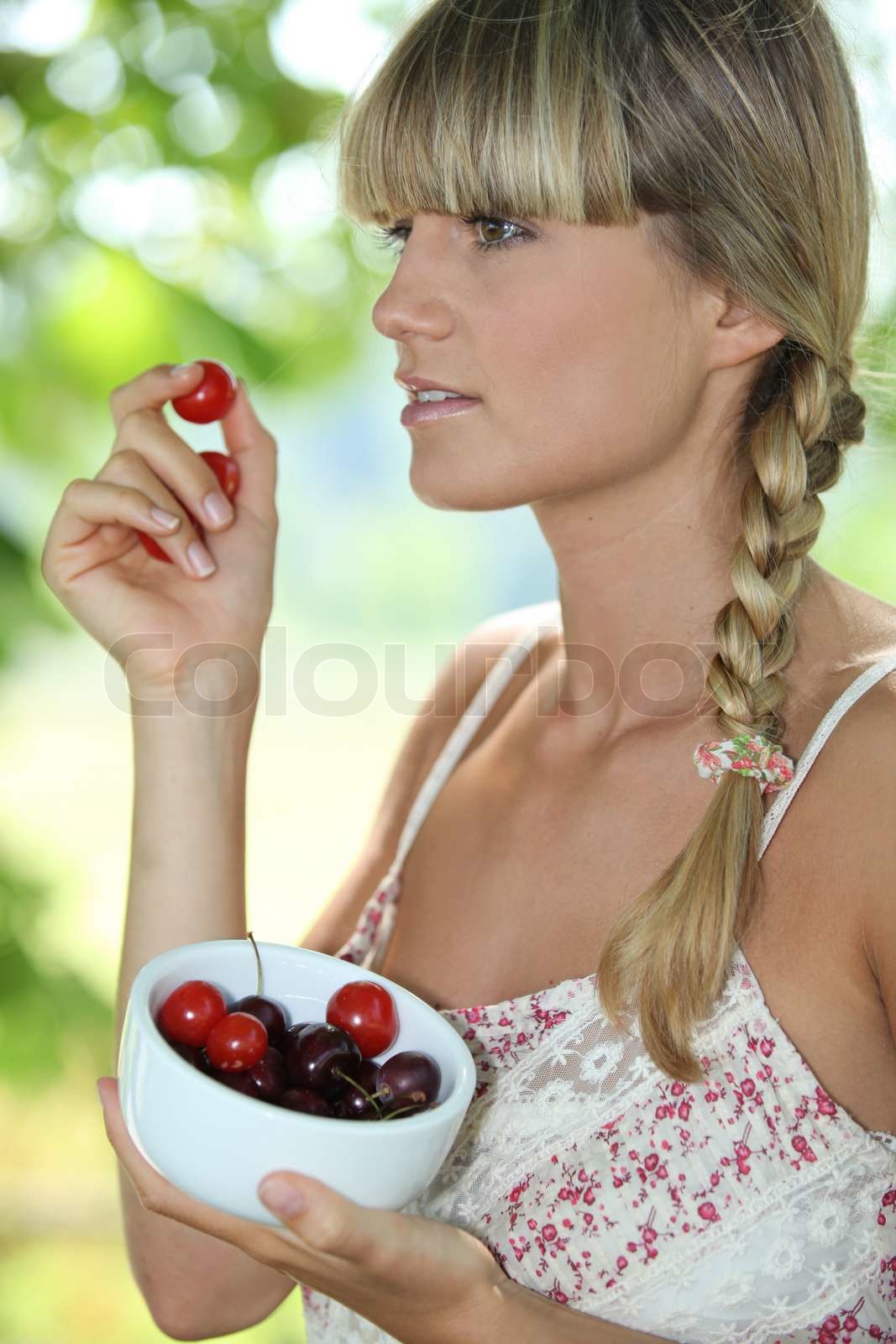 Woman eating cherries | Stock image | Colourbox