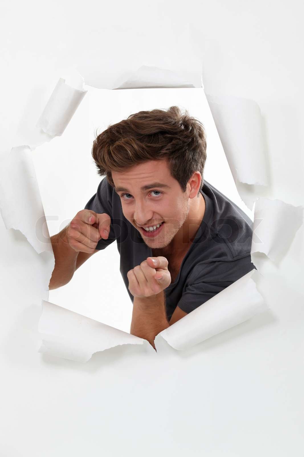 Men coming out of torn paper hole | Stock image | Colourbox