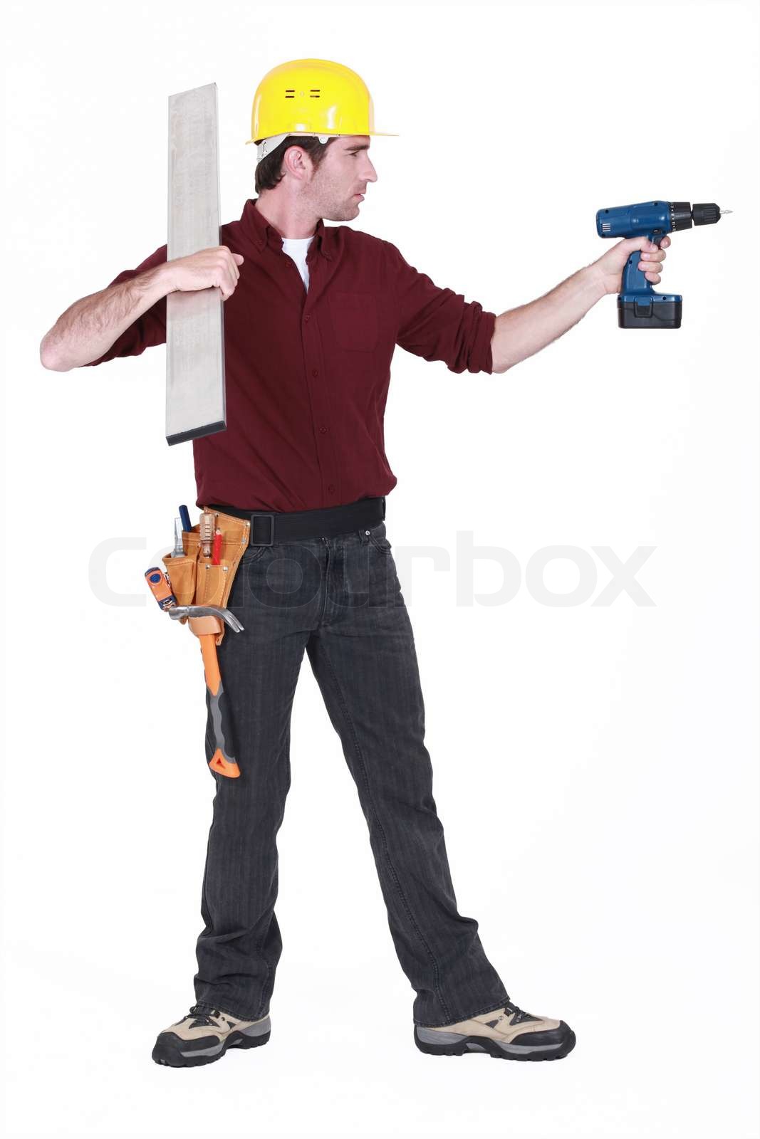 Tradesman holding a girder and a power tool | Stock image | Colourbox