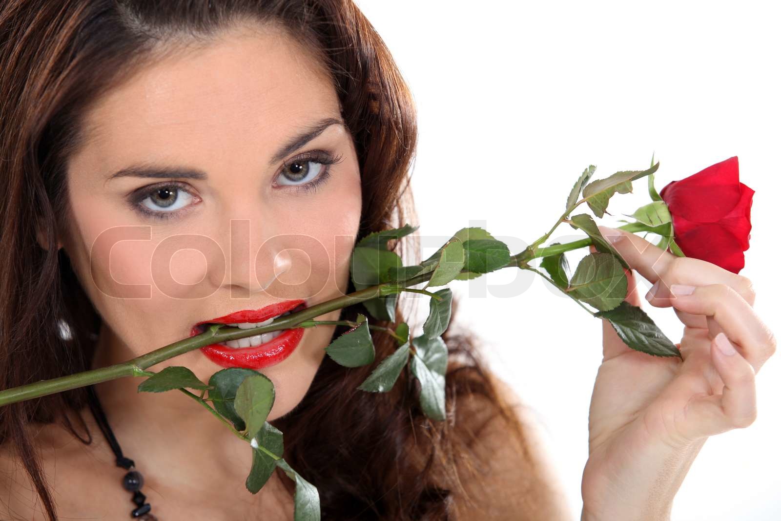Woman with a red rose in her teeth | Stock image | Colourbox