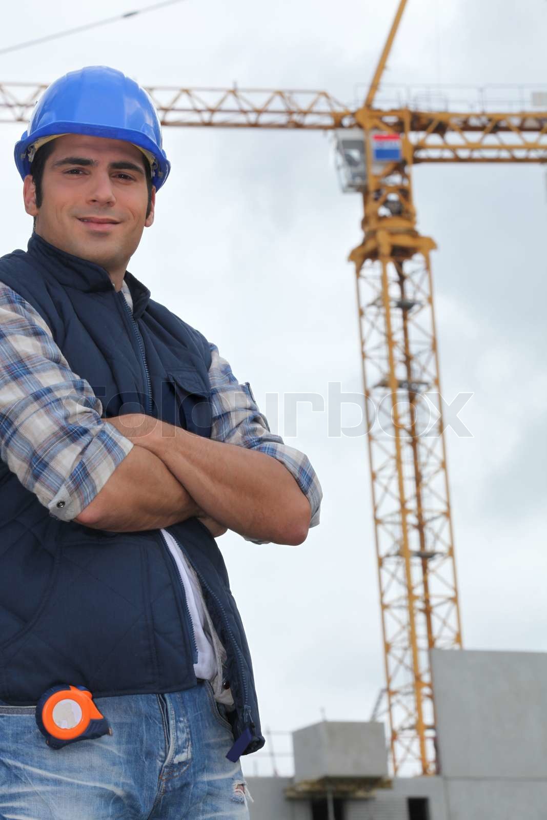 Construction worker in front of a crane | Stock image | Colourbox
