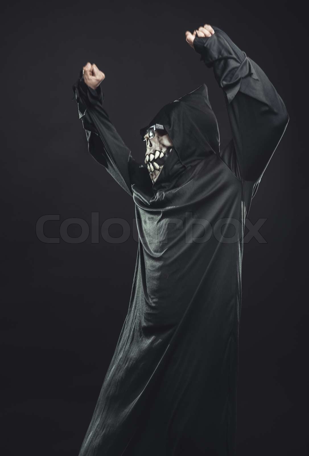 skeleton in a black robe with glasses dancing | Stock image | Colourbox