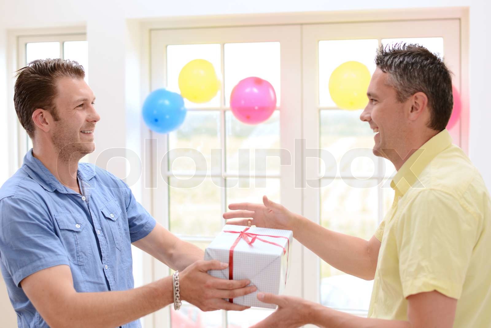 Friends give birthday present | Stock image | Colourbox