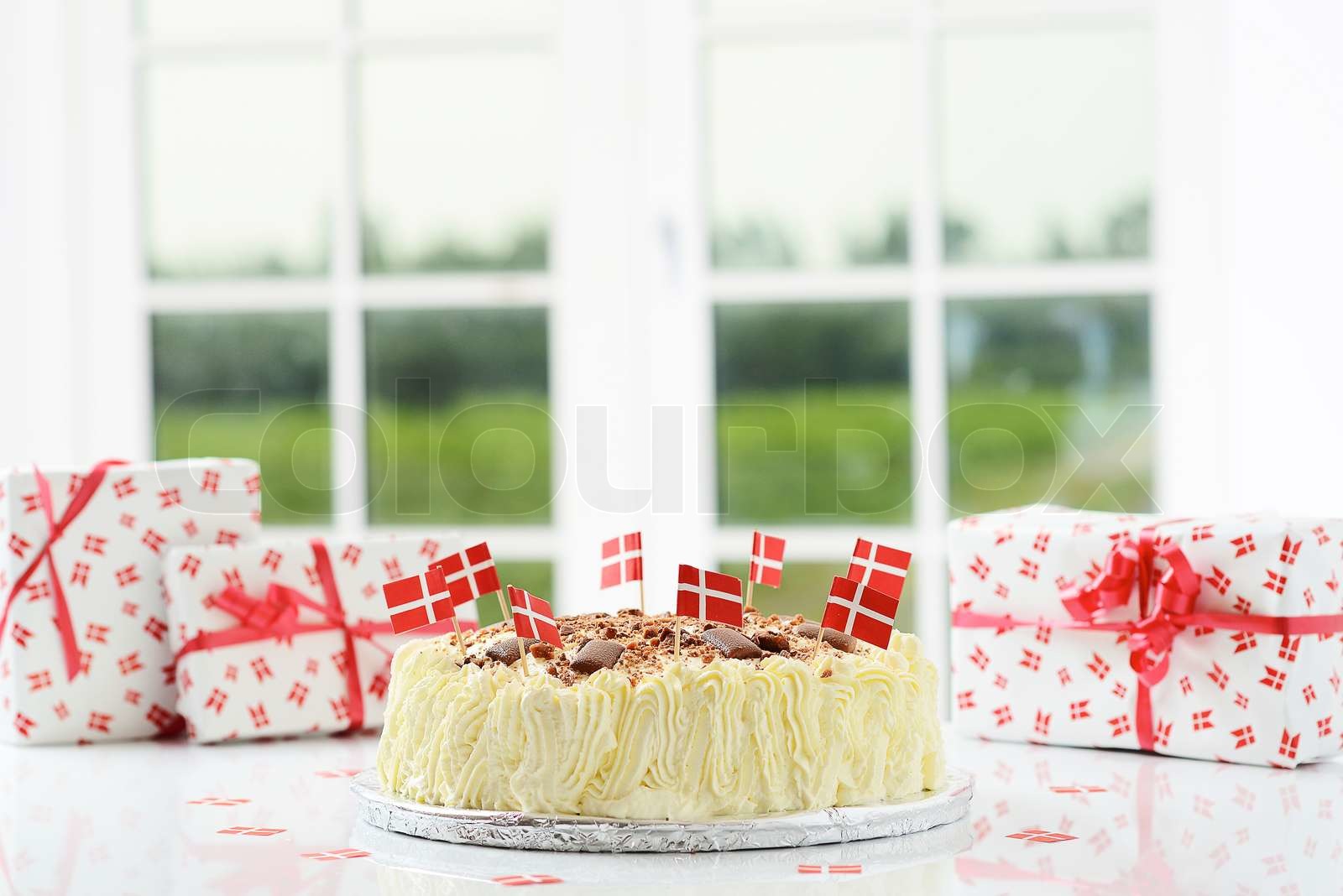 Fødselsdag med en lagkage med flødeskum, glasur, flag og gaver | Stock ...