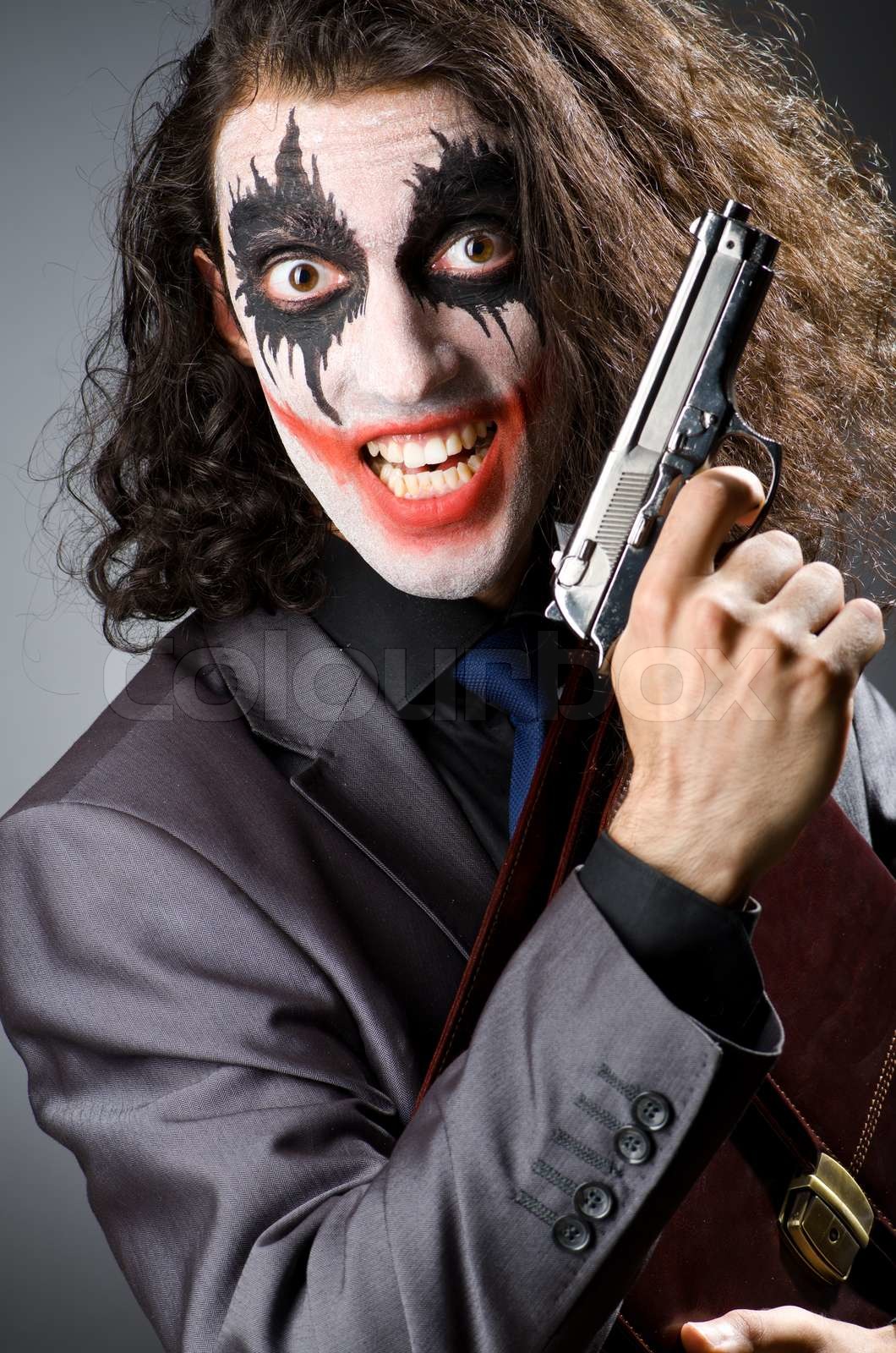 Joker with gun and briefcase | Stock image | Colourbox