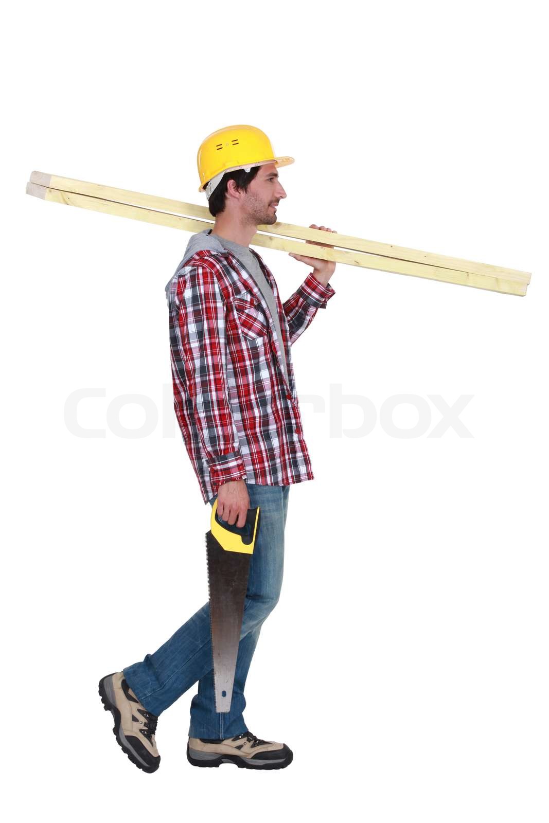 Profile of a carpenter with wood and a saw | Stock image | Colourbox