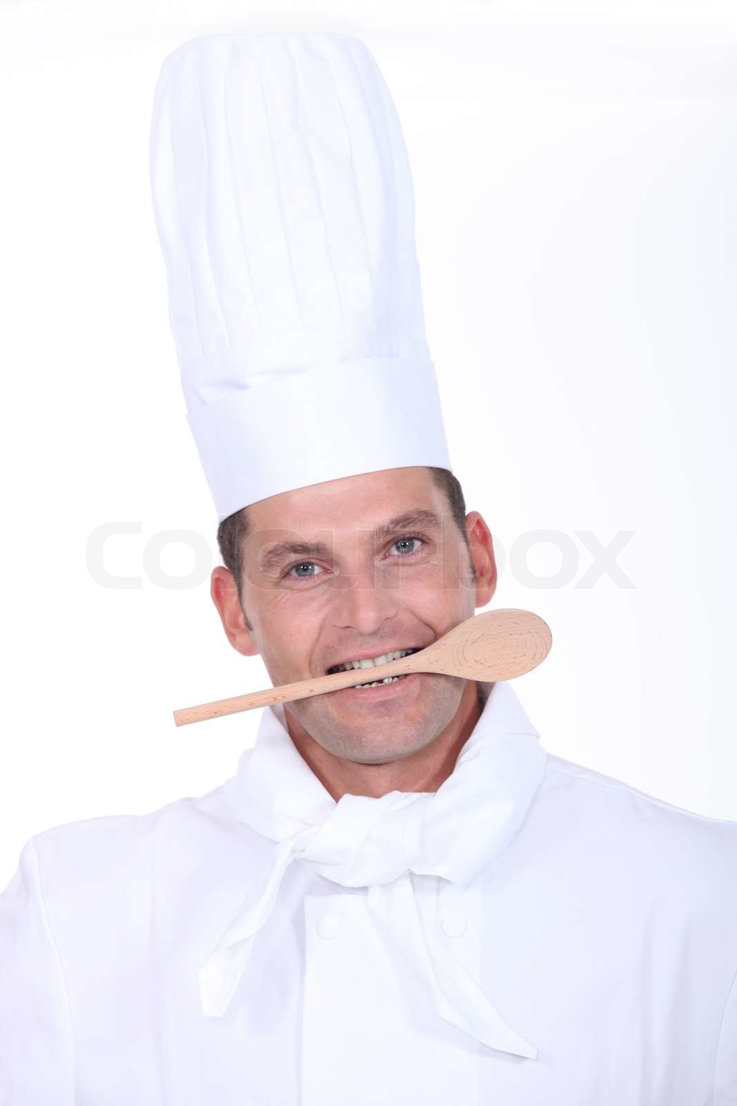 male cook with a wooden spoon in the mouth | Stock image | Colourbox